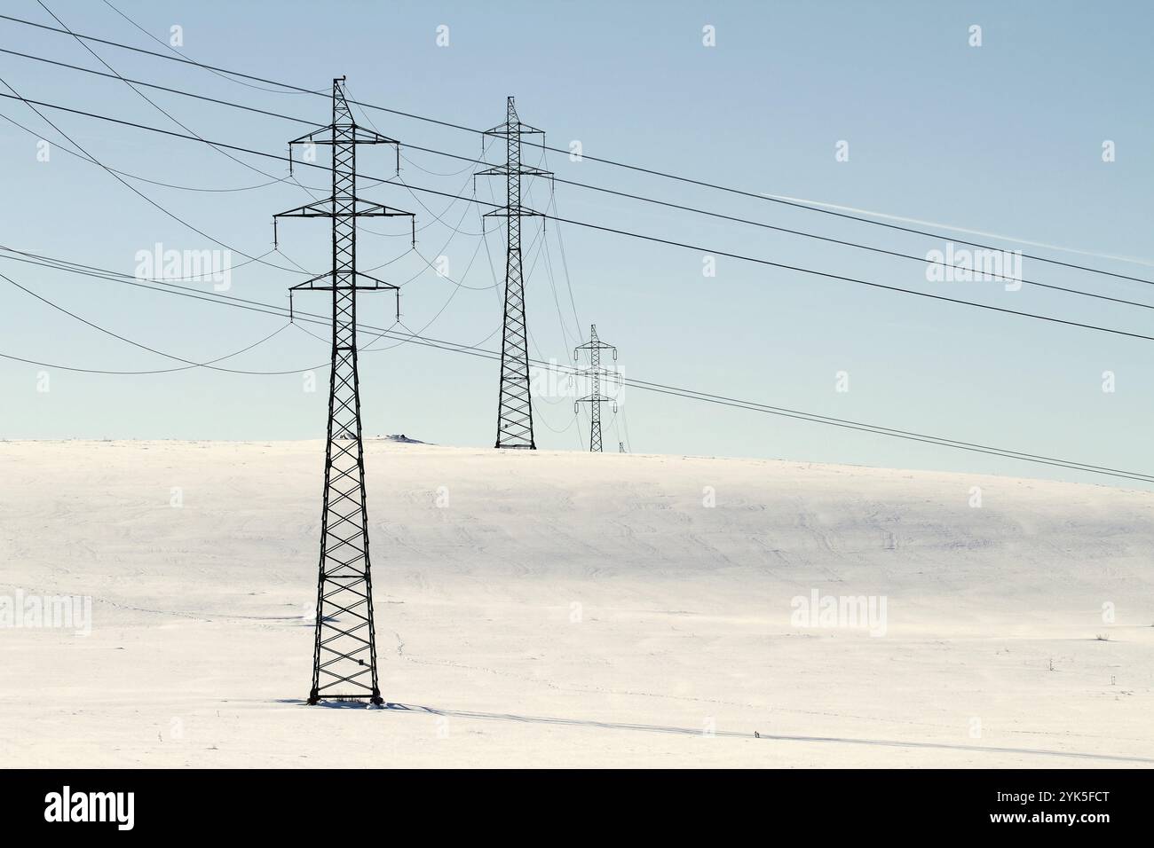 High voltage electricity power pylon on snowy field Stock Photo - Alamy