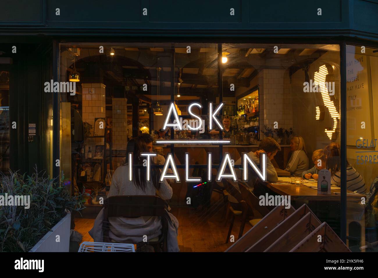 View through a window into people dining in an Ask Italian restaurant ...