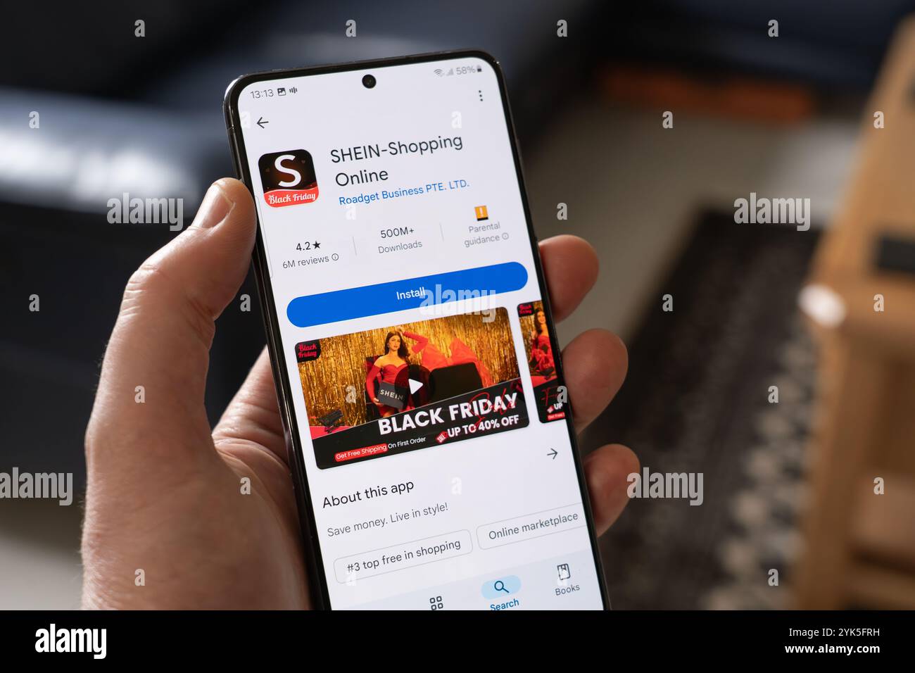 Hand holding the Shein install screen on a smartphone with a Black ...