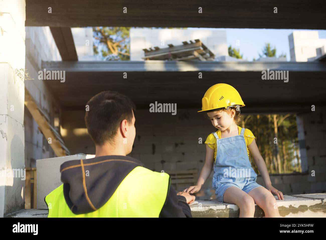 Dad and daughter are at construction site of their future home. The ...