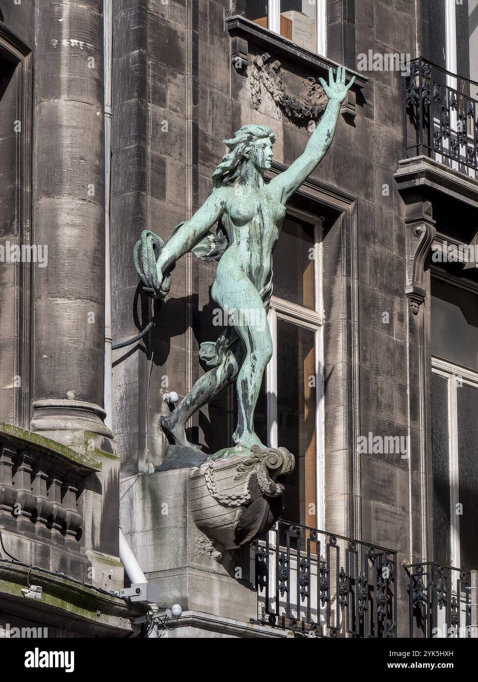 Bronze sculpture of a woman on the facade of the historic Hansa Huis ...