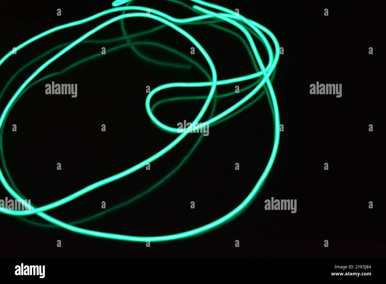 Unusual glowing thin bright green, blue thread, twisting wire ...