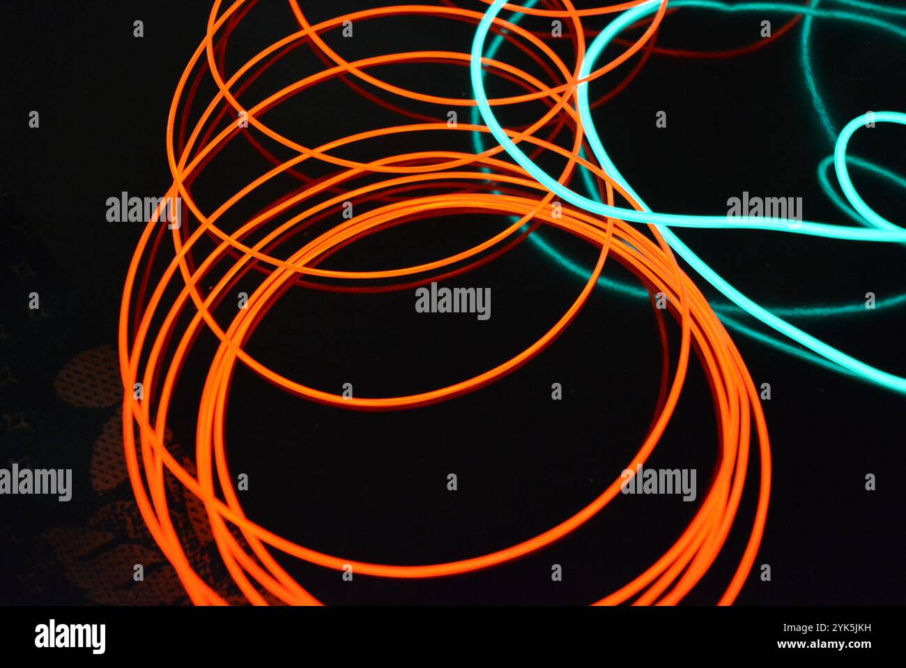 Unusual glowing blue and red thread, twisting wire, structural and ...