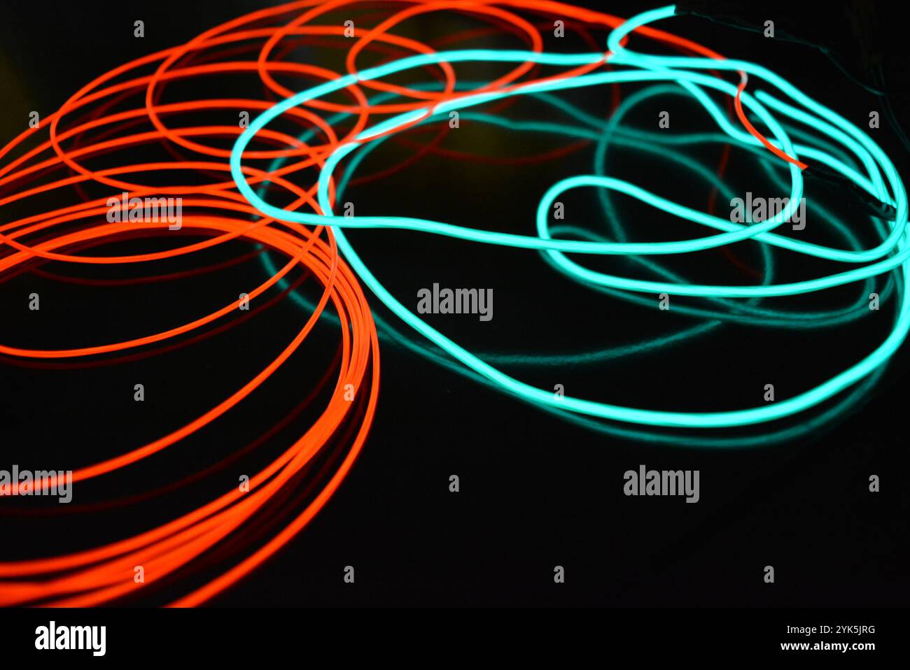 Unusual glowing blue and red thread, twisting wire, structural and ...