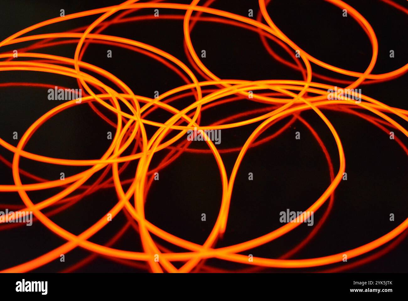 Unusual glowing thin red thread, twisting wire, structural and curved ...