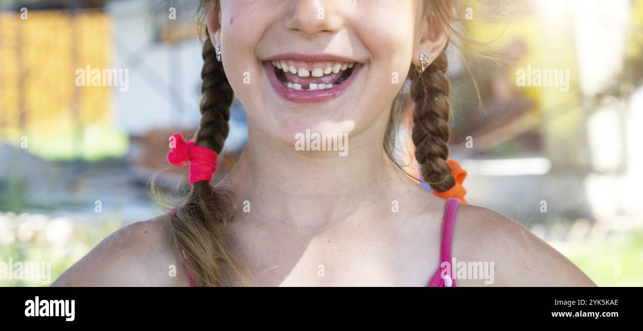 Toothless happy smile of a girl with a fallen lower milk tooth close-up ...