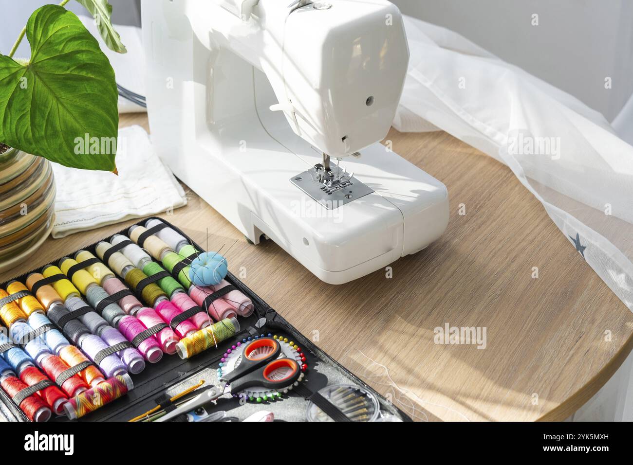 Sewing layout with multicolored spools of thread close-up, needles ...