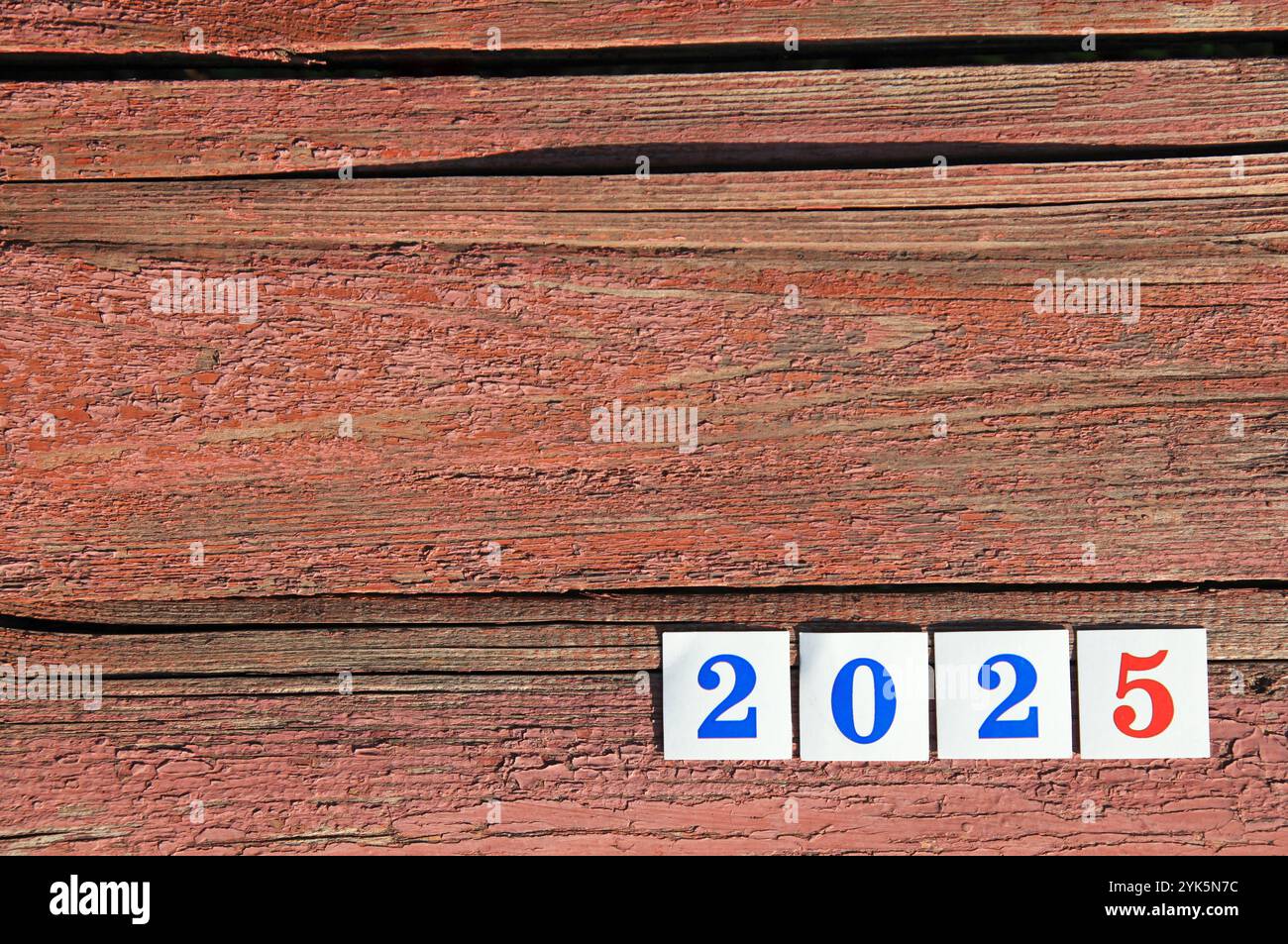 Numbers of 2025 year. Paper square numbers on the wooden fence ...