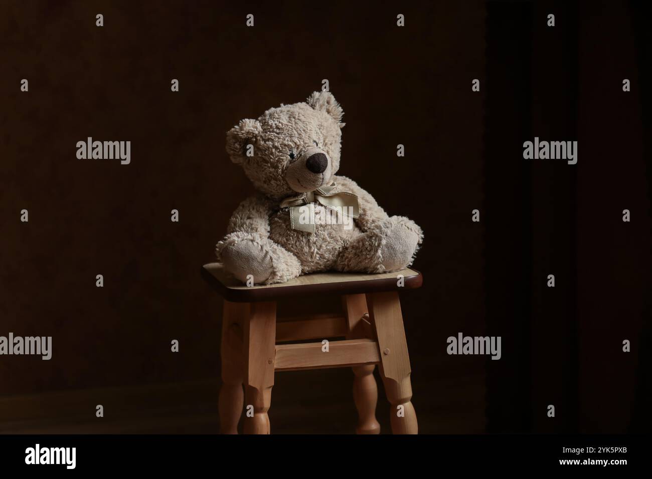 Lonely teddy bear sitting on a chair. A lone Teddy bear sitting in the ...