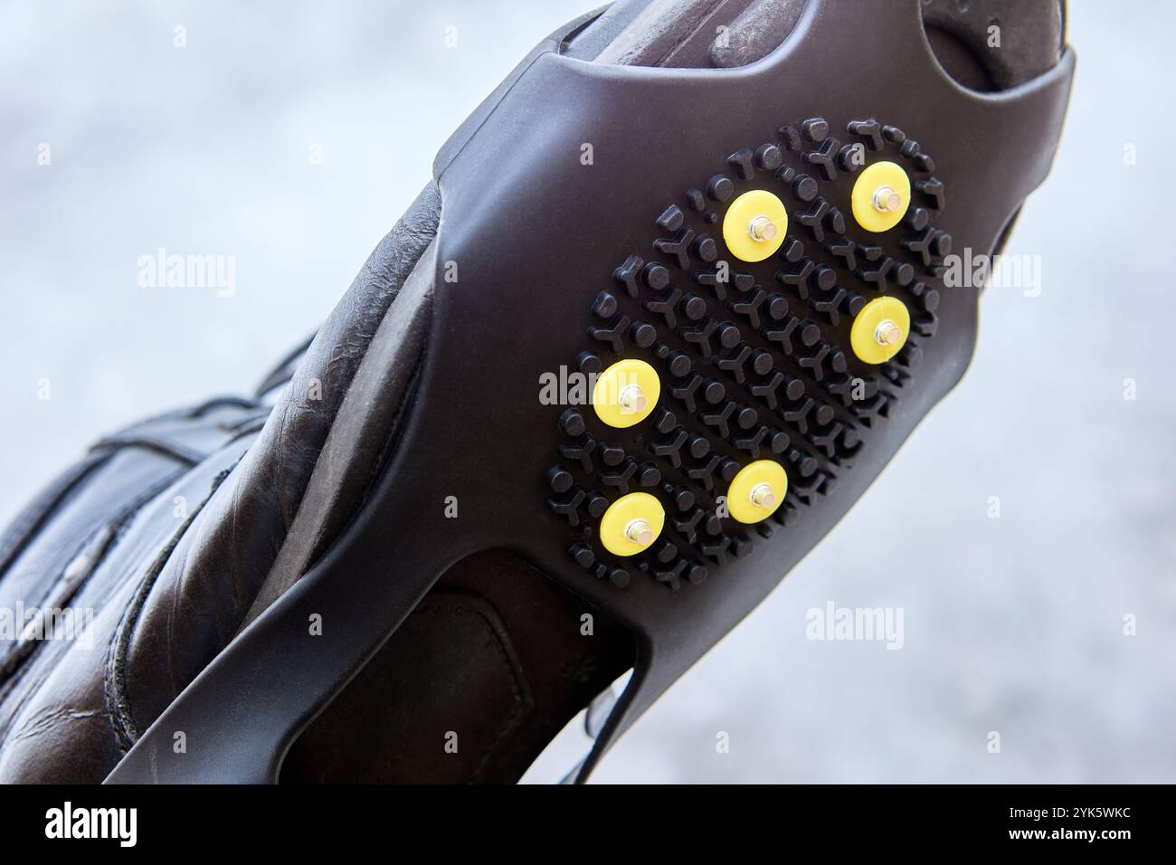 Overlay anti-slip spikes on soles of winter shoes to improve traction ...
