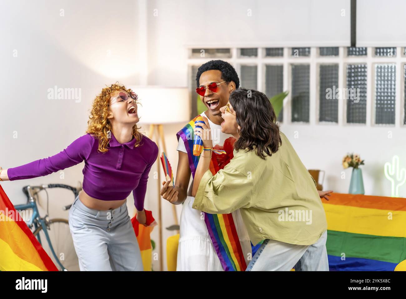 Multi-ethnic gay friends singing karaoke with toy mic celebrating pride ...