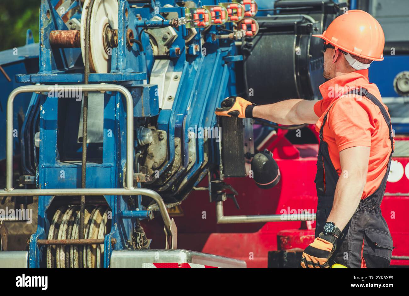A construction worker in safety attire is controlling heavy machinery ...