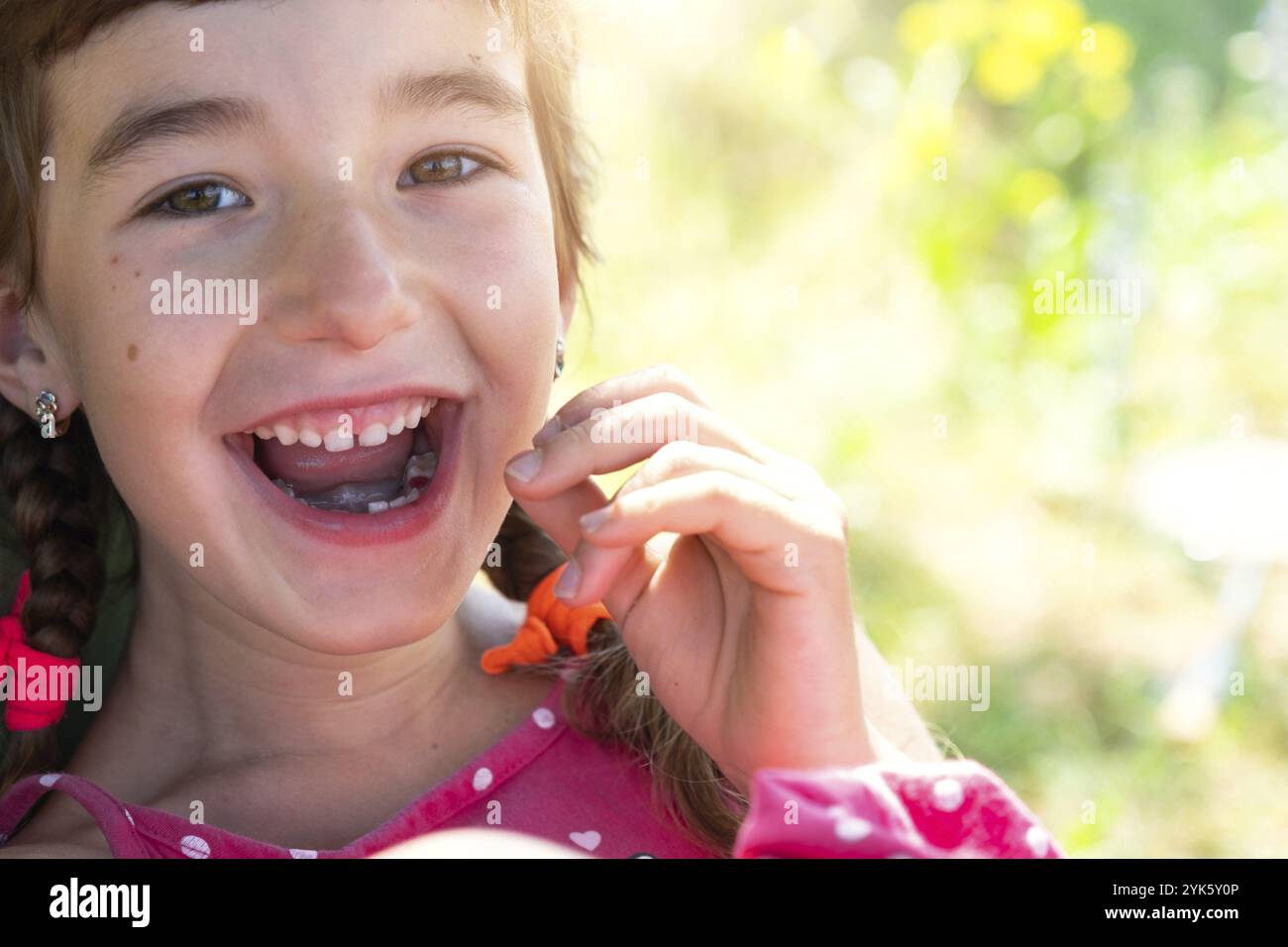 Toothless happy smile of a girl with a fallen lower milk tooth close-up ...