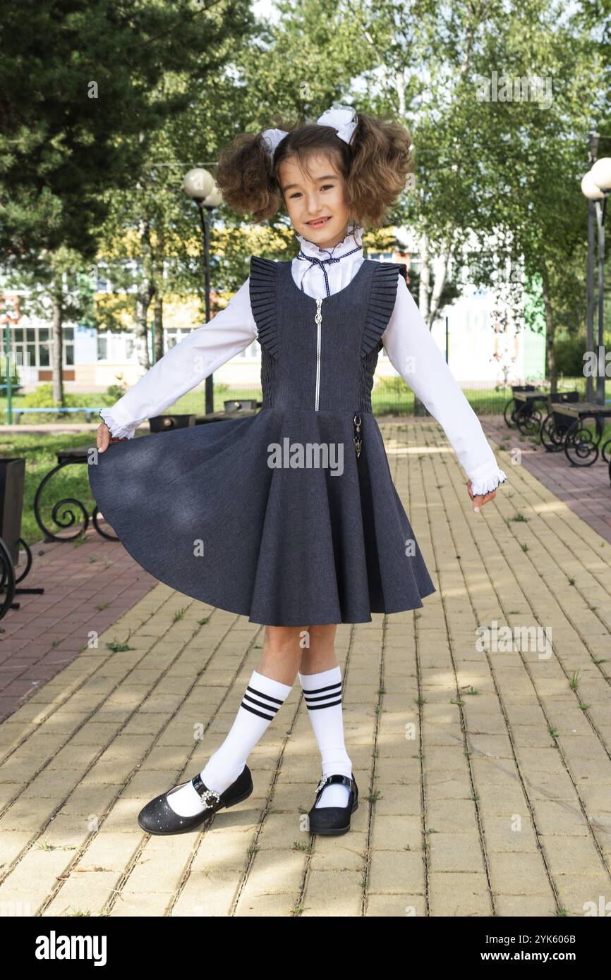 Cheerful funny girl with a toothless smile in a school uniform with ...