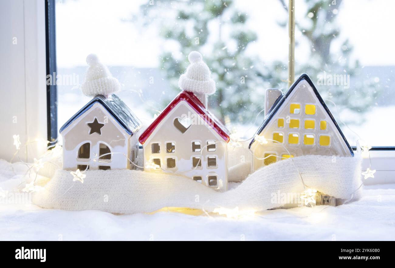Cozy house is wrapped in a hat and scarf in a snowstorm -window sill ...