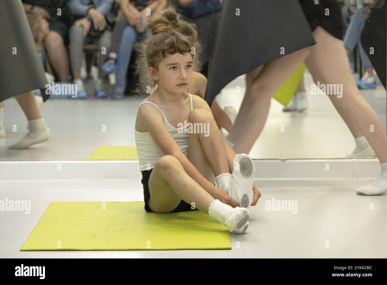 Child trains in gym on the mat, does stretching exercises and abs ...