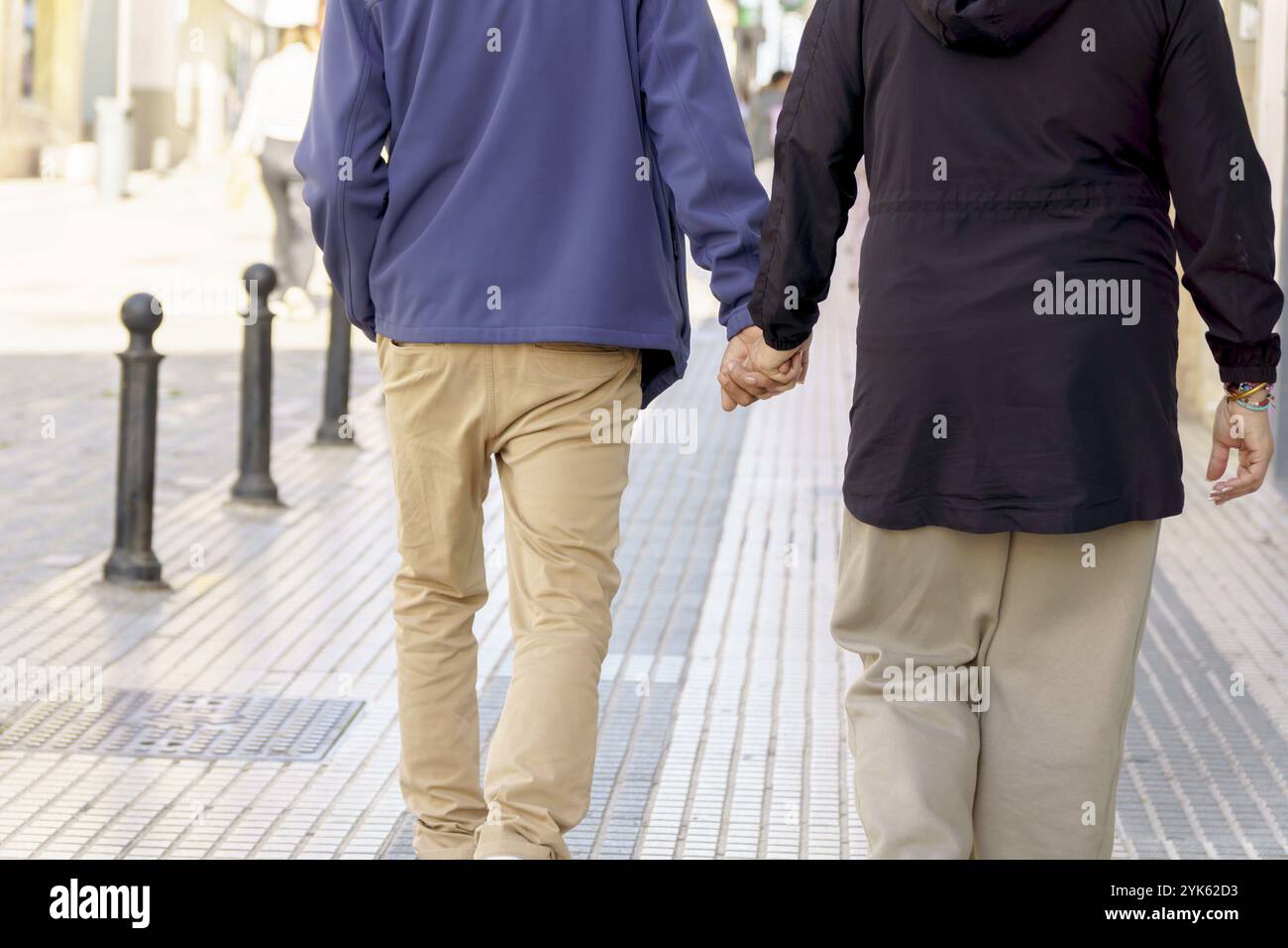 Couple strolling hand in hand along a pedestrian street Stock Photo - Alamy