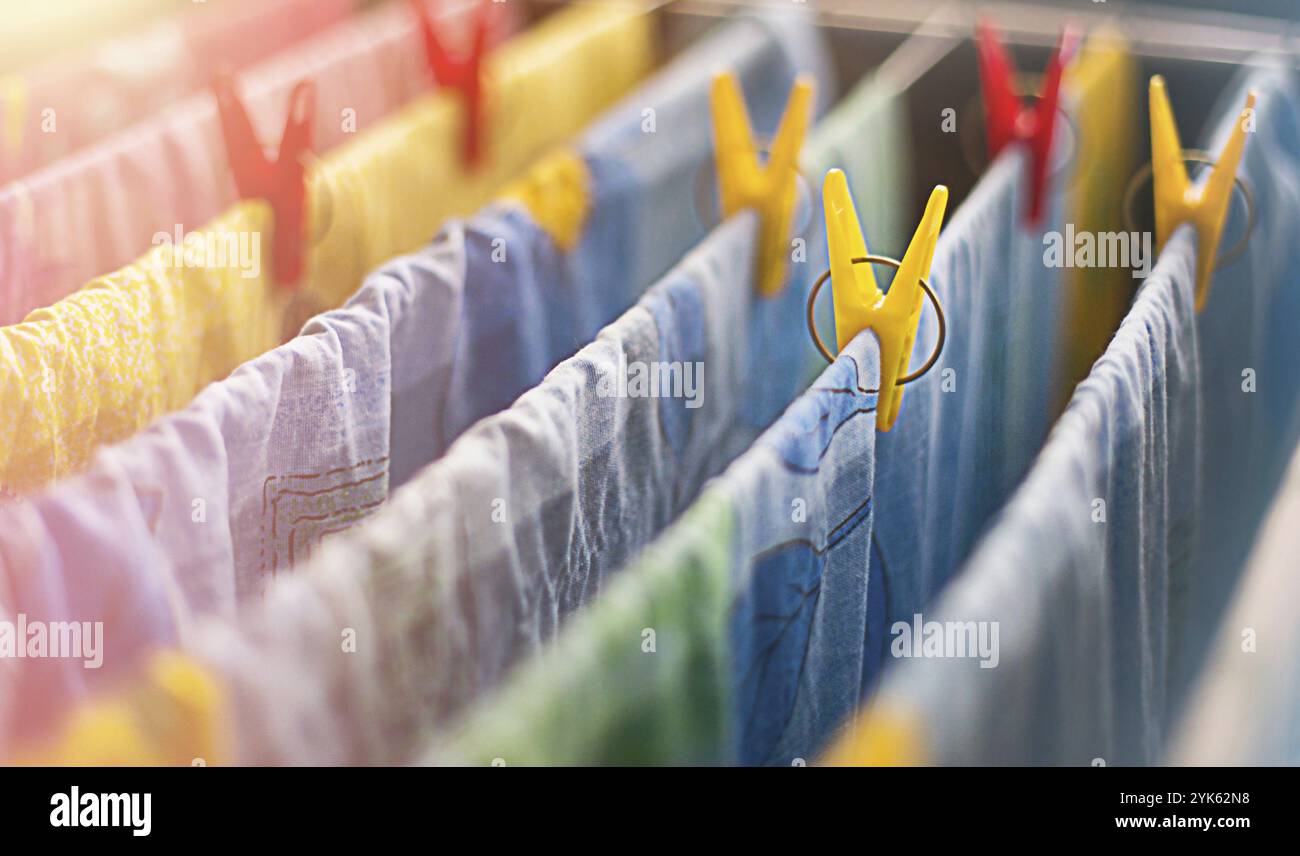 Colorful clean bed linen and towels after washing are hung on the bars ...