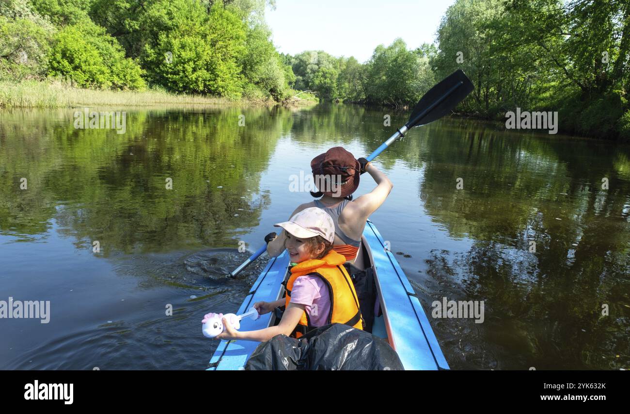 Family kayak trip. Mom and daughter rowing a boat on the river, a water ...
