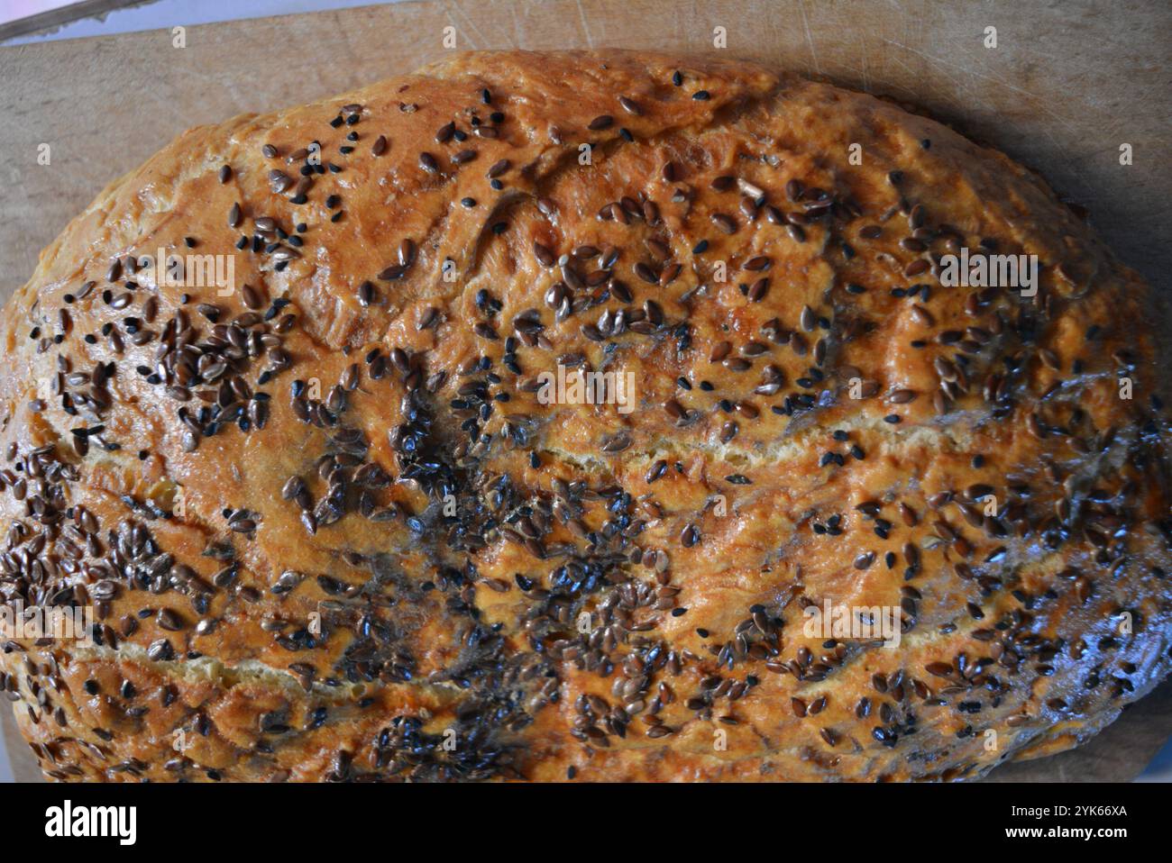 Fresh, delicious toasted bread made at home. A loaf of bread with black ...