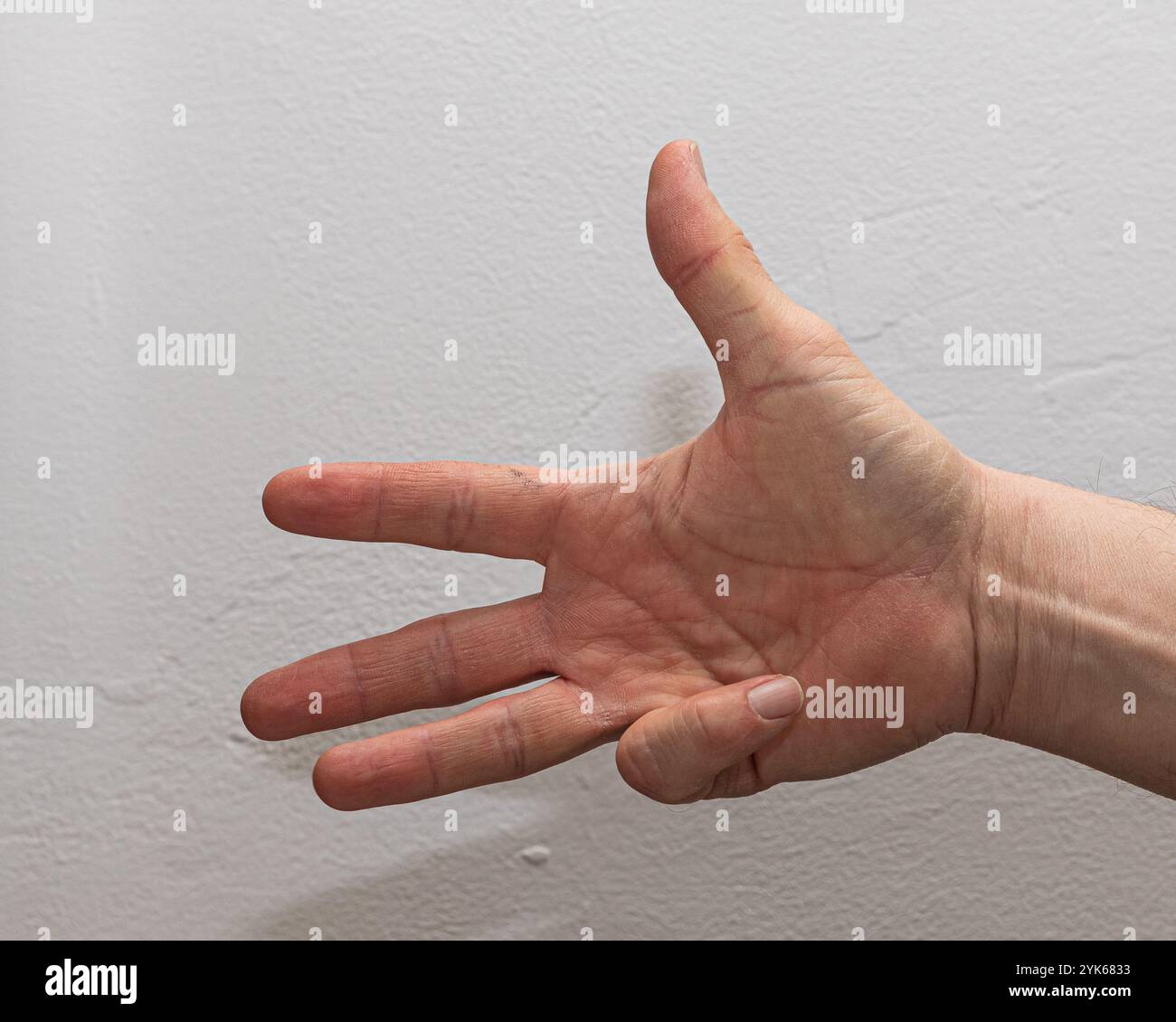 Close-up view of a hand showing four fingers extended, captured against ...