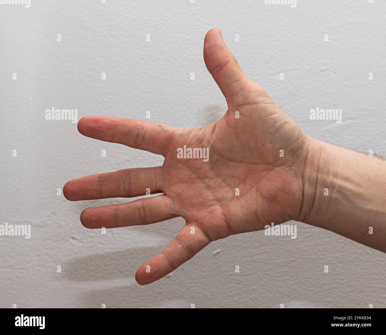 A detailed close-up of a hand displaying all five fingers spread out ...