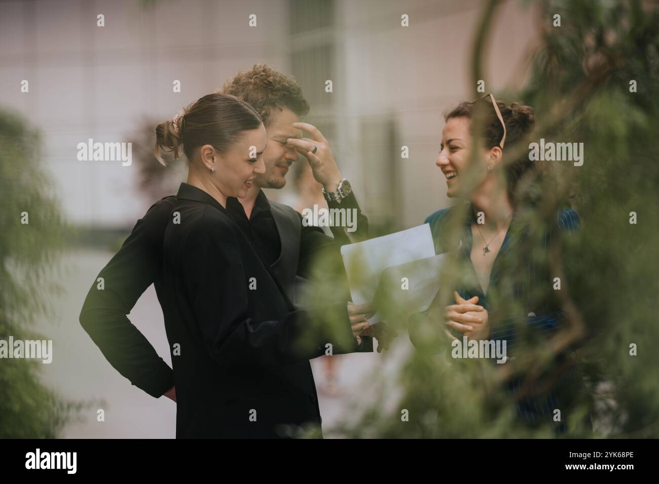 Group of colleagues laughing and discussing work outdoors in a friendly ...