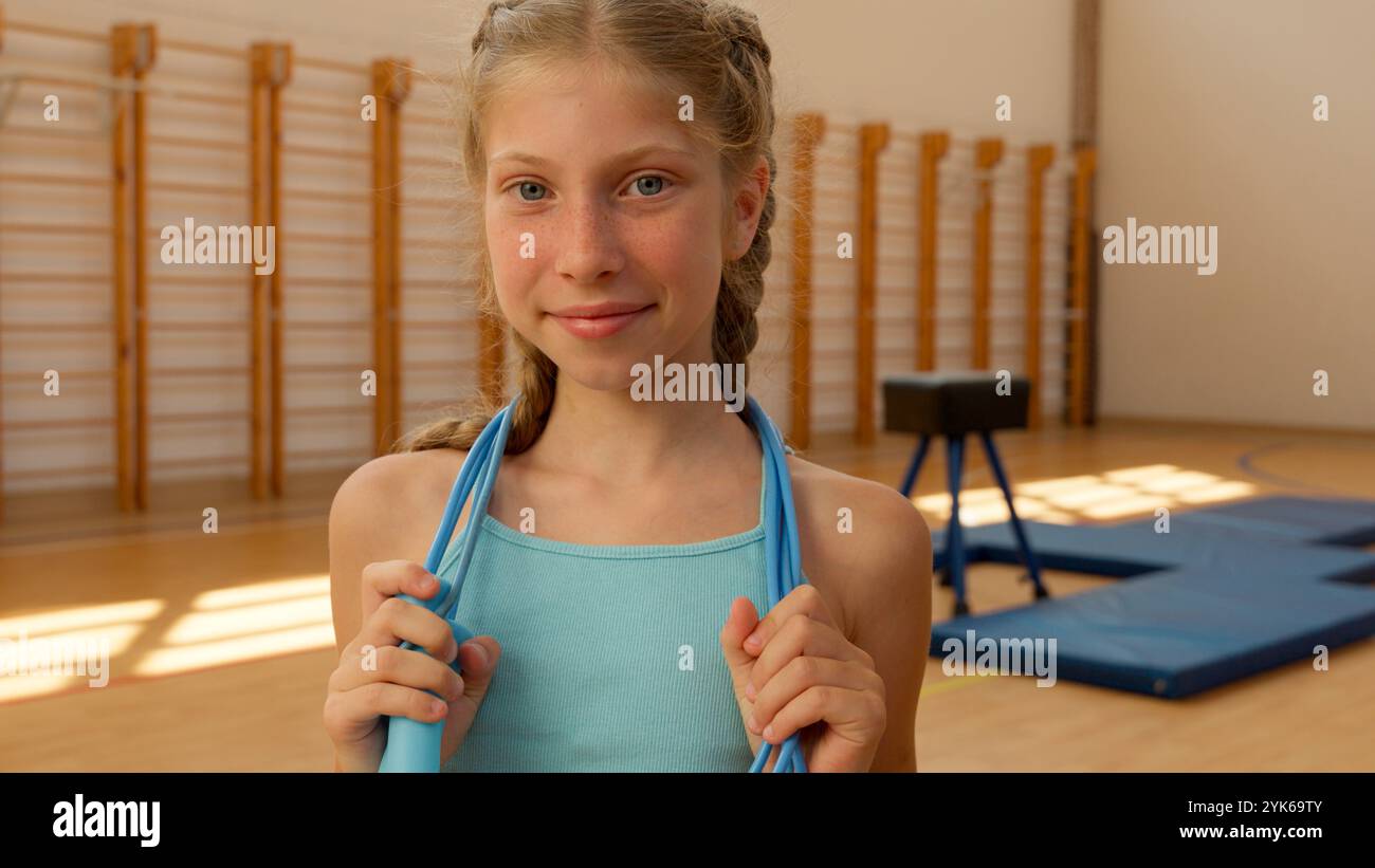 Smiling little girl sportswoman gymnast champion with skipping rope in ...