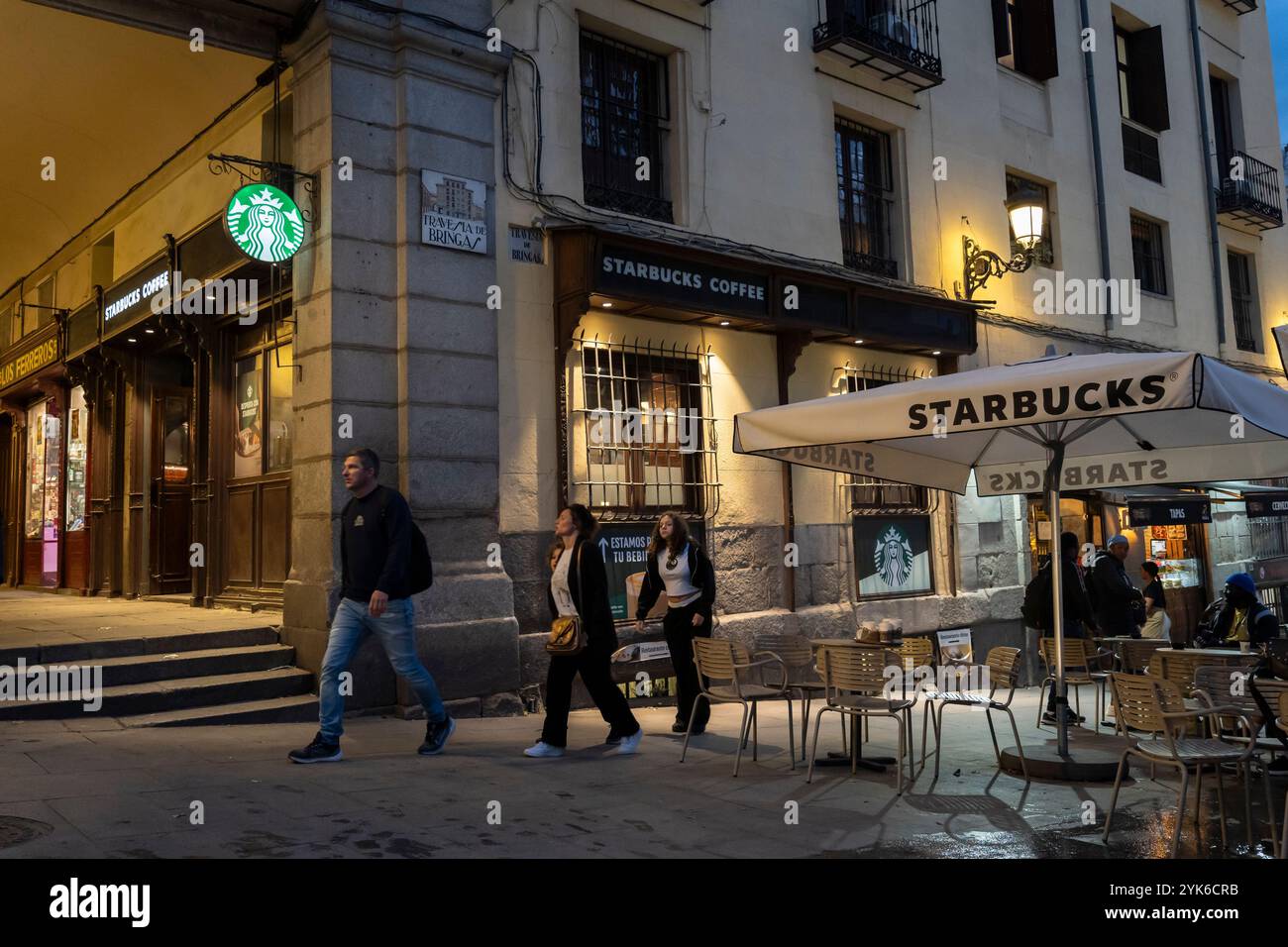 Visitors walk past a Starbucks coffee shop in the historic Los Austrias ...