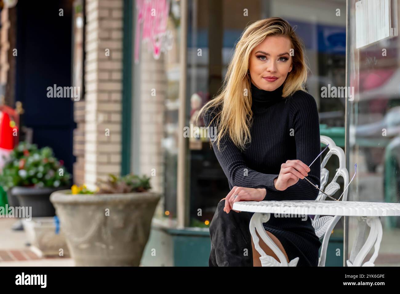 A gorgeous blonde woman strolls through a quaint small town, wrapped in ...