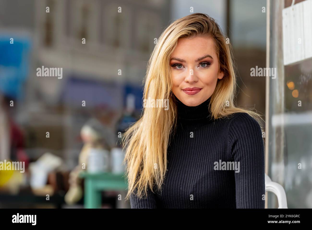 A gorgeous blonde woman strolls through a quaint small town, wrapped in ...