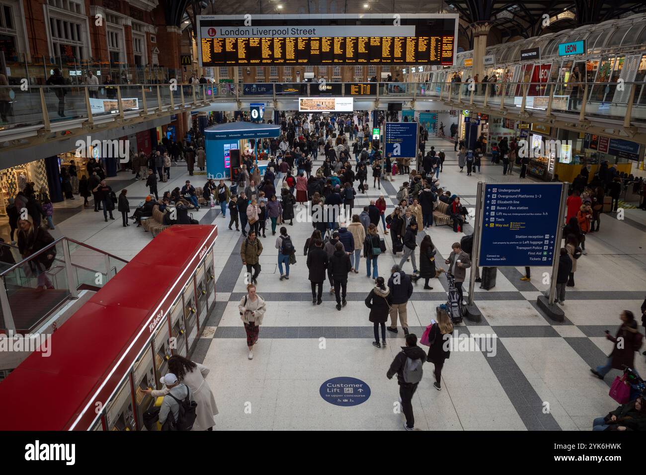 Liverpool St. Passengers wait for trains and watch the station boards ...