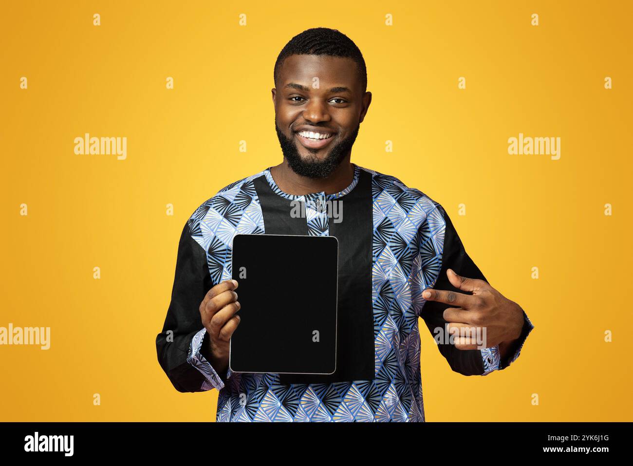 Smiling black guy pointing at digital tablet with empty screen Stock ...