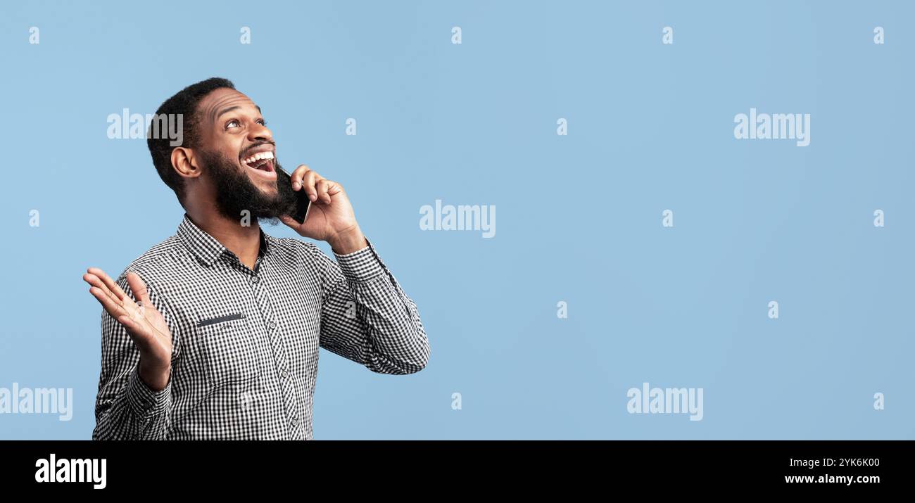 Smiling black man talking on the phone, blue background Stock Photo - Alamy
