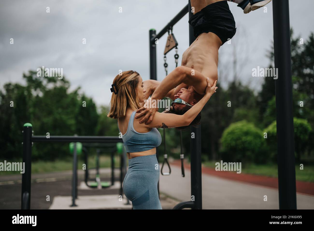 Fit couple performing an outdoor calisthenics workout in a park Stock ...