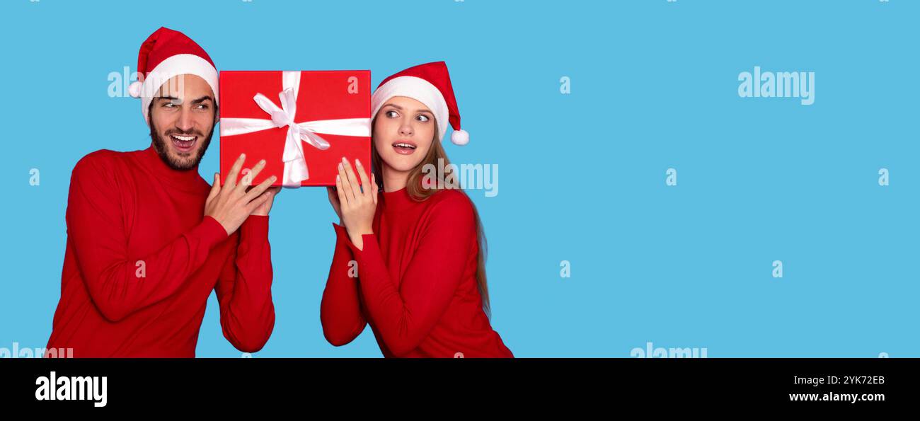 Surprise Gift. Excited Young Couple Shaking Wrapped Box With Christmas ...