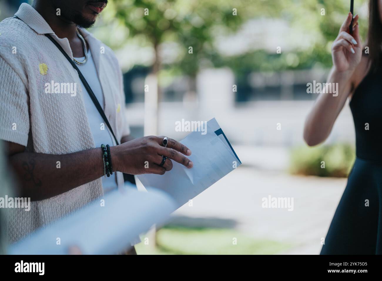 People reviewing documents outdoors in a casual setting Stock Photo - Alamy