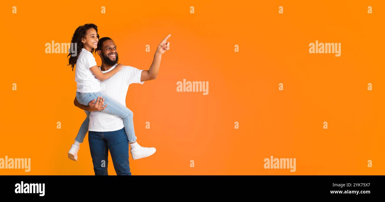 Smiling black dad pointing aside at copy space at studio Stock Photo ...