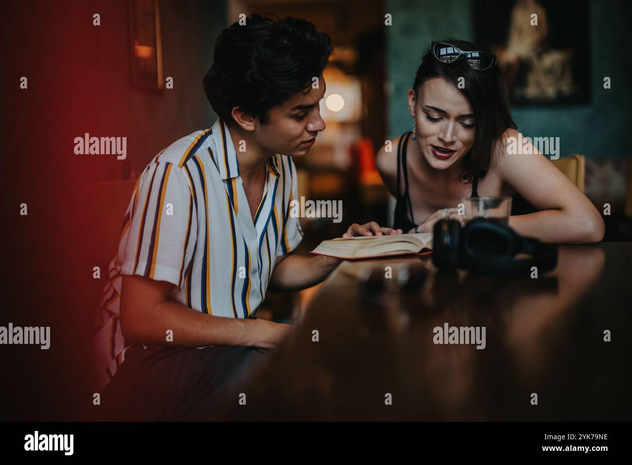 Two friends enjoying a cozy reading session together at a cafe Stock ...