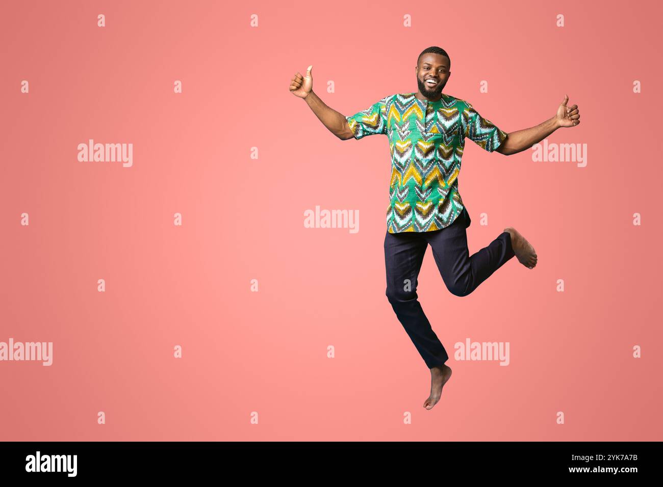 Positive black man jumping up over blue Stock Photo - Alamy