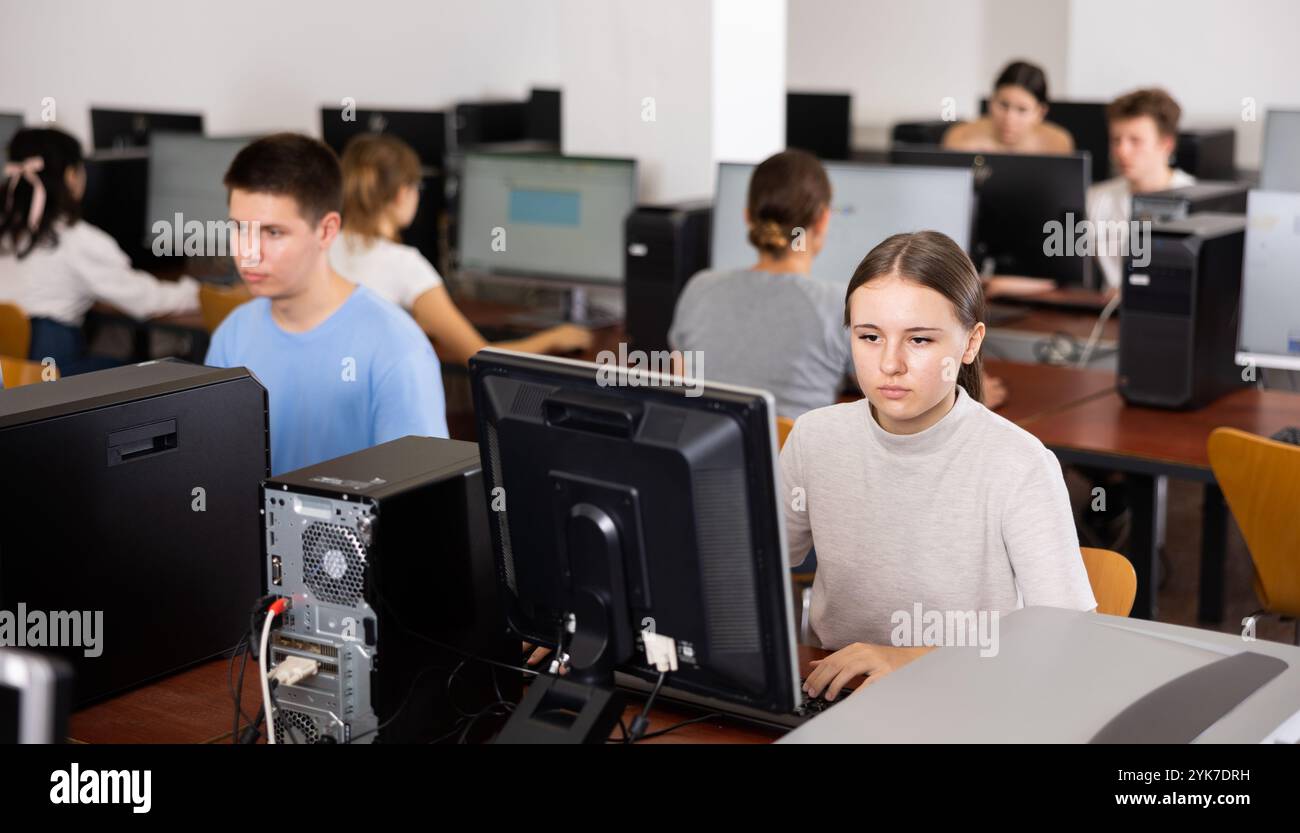 Group of young smart students studying together in computer class ...