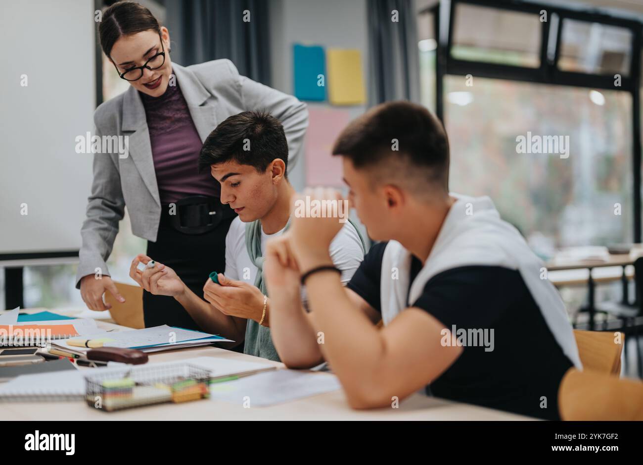 Teacher guiding students during collaborative classroom learning session Stock Photo - Alamy