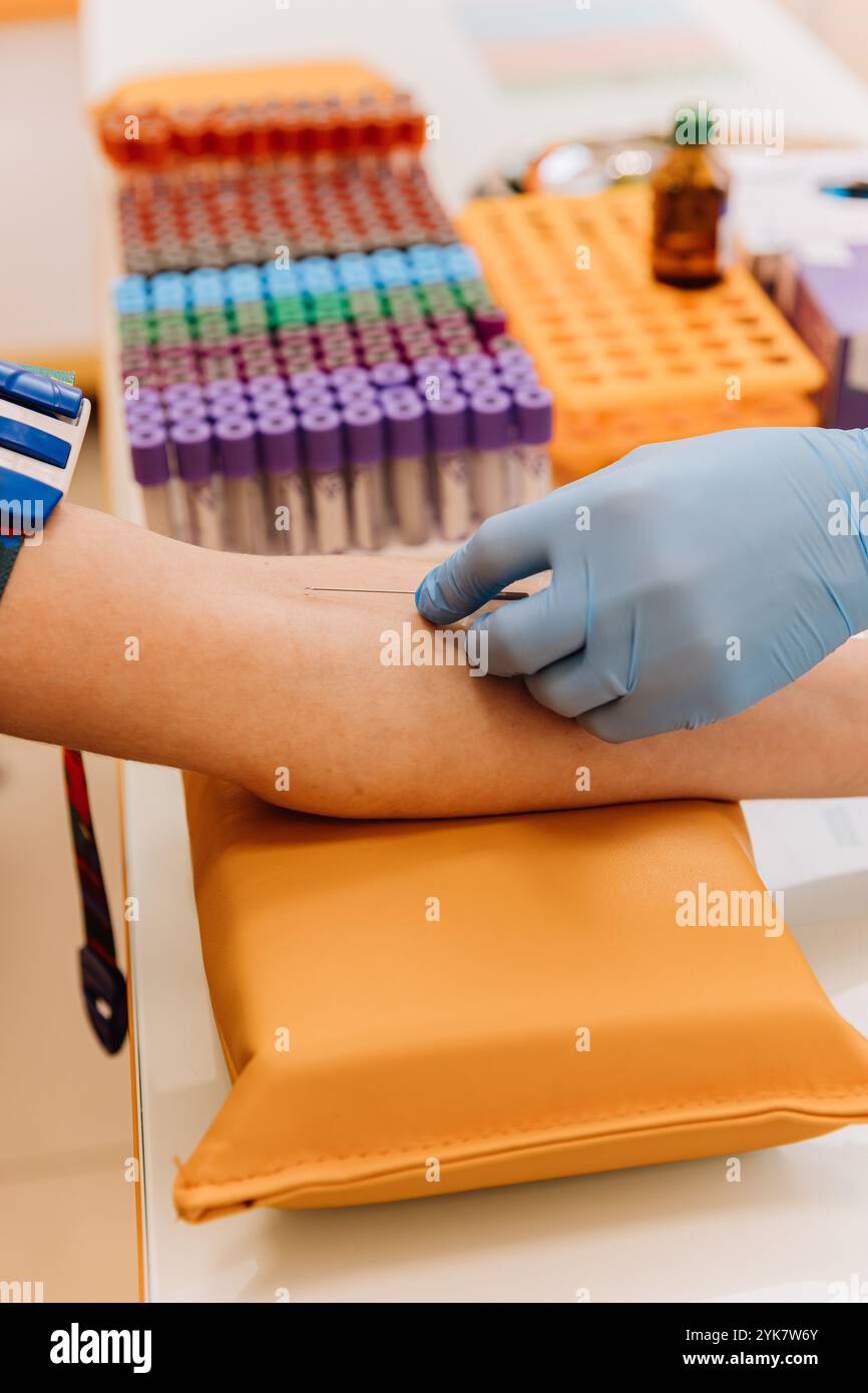 Healthcare professional preparing for a blood draw in a clinical ...