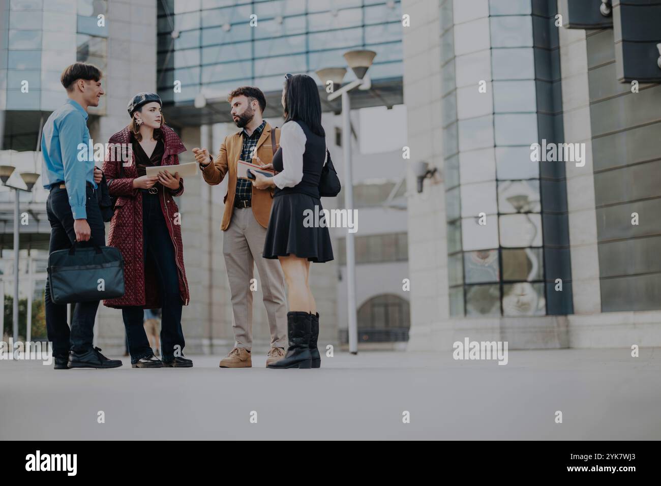 Business professionals having a discussion outside a modern office ...