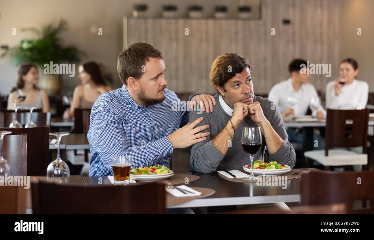Sad male friends talking drinking hi-res stock photography and images ...