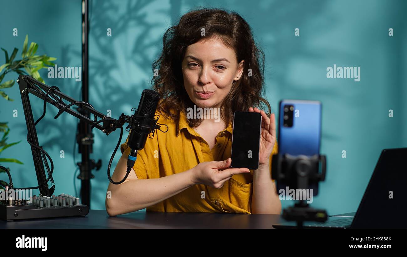 Smartphone on holder capturing footage of reviewer discussing with ...