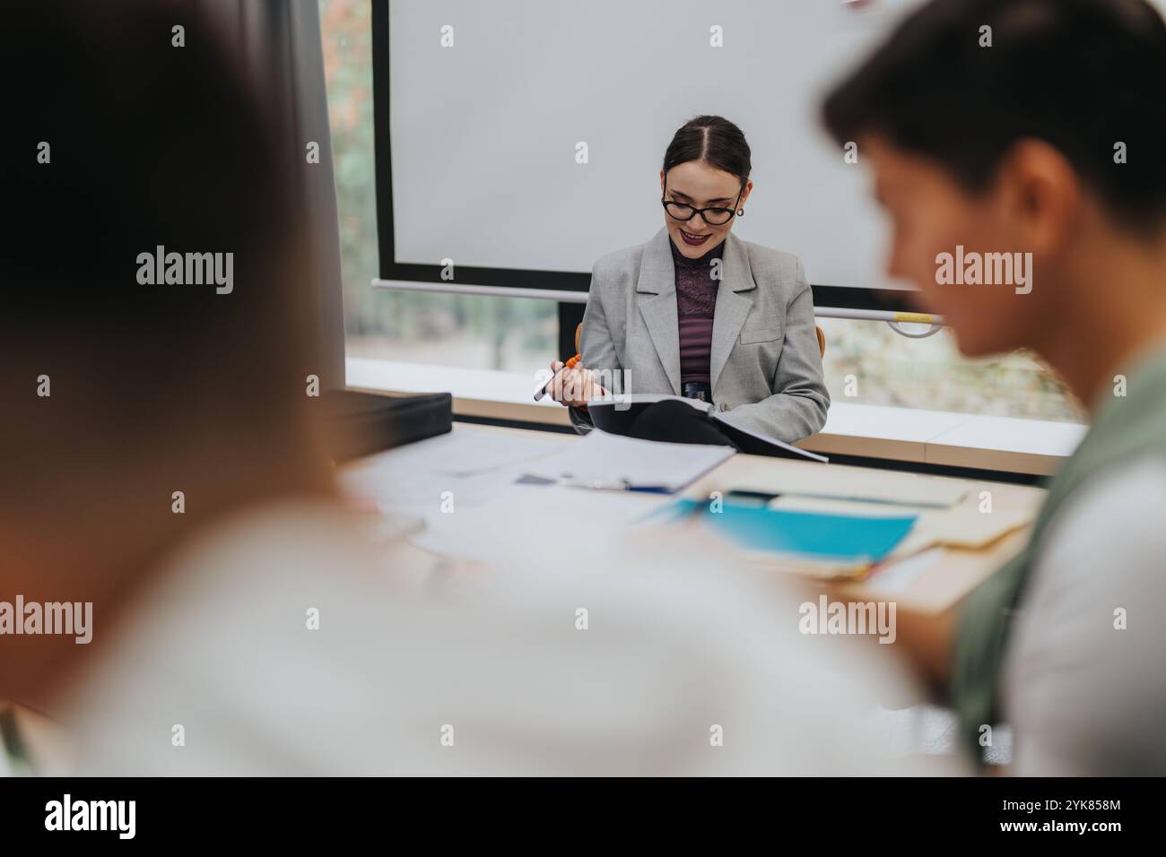 Teacher leading classroom discussion with attentive students present ...