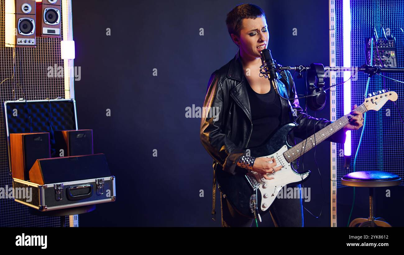 Female rock star singing a heavy metal song while playing her guitar ...