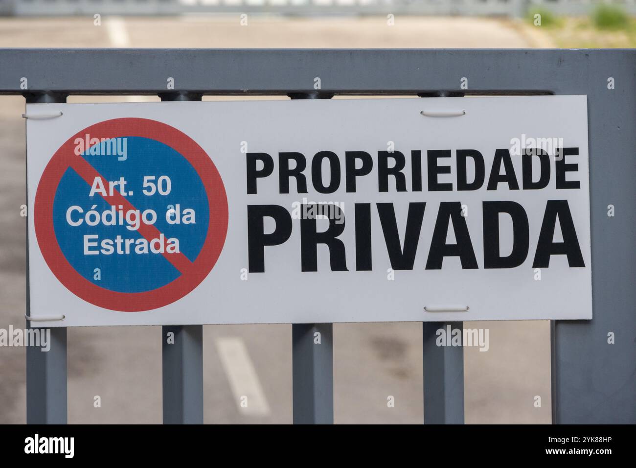 Private property sign in portuguese hanging on a metal gate, indicating ...