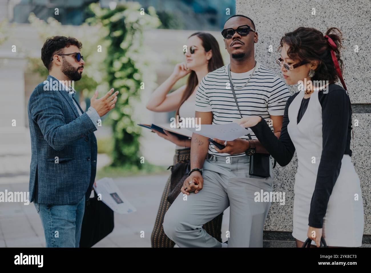 Four young professionals having an outdoor business meeting discussion ...